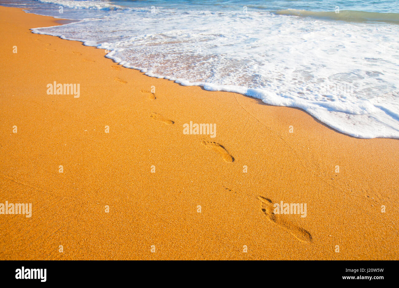 beach, wave and footprints at sunset time Stock Photo - Alamy