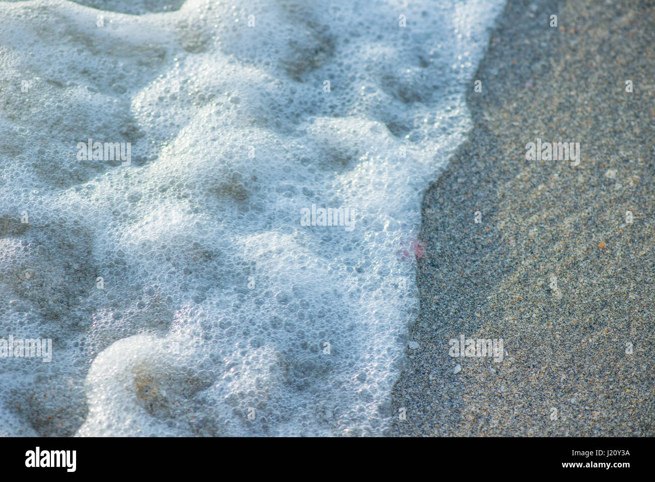 Sea foam rolls in on the white hot sand beaches at Captiva Island of a ...
