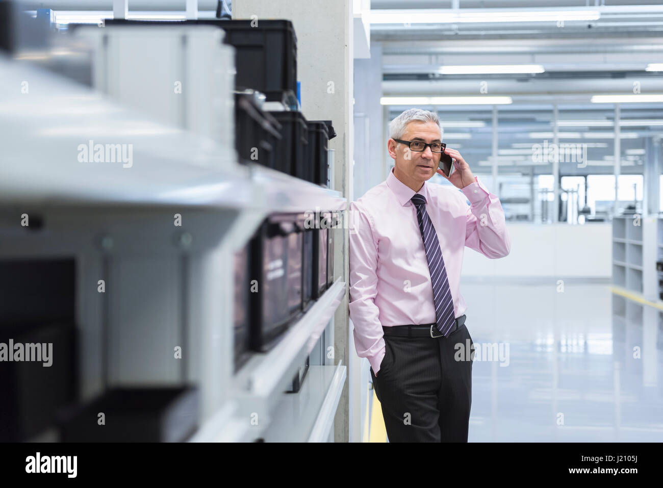 Manager on shop floor of a factory using smart phone Stock Photo - Alamy