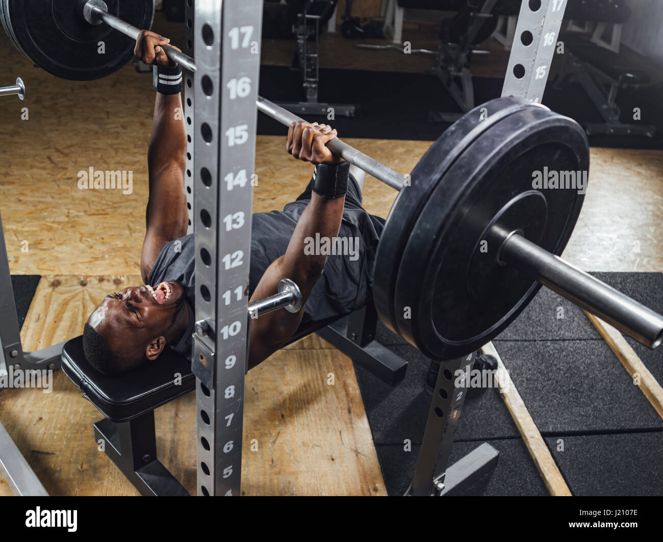 Athlete in gym doing weight lifting Stock Photo - Alamy