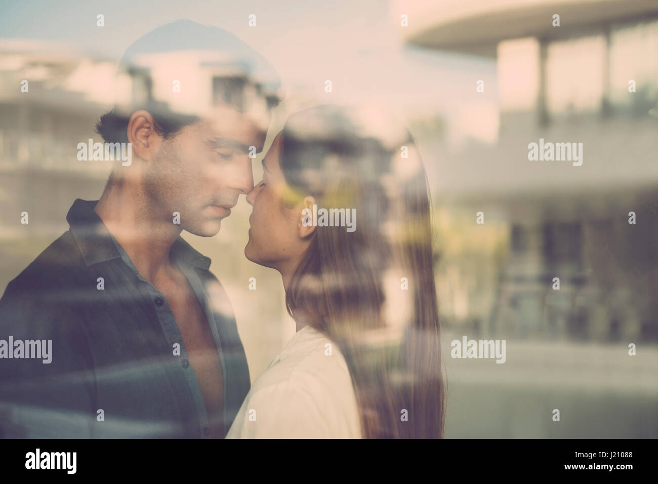 Young couple in love behind windowpane Stock Photo - Alamy