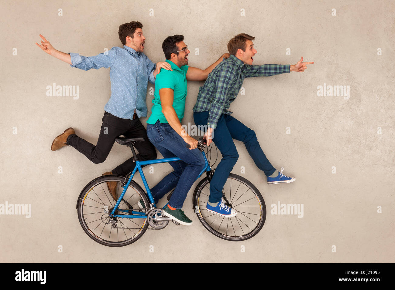 Three friends riding on one bicycle Stock Photo - Alamy
