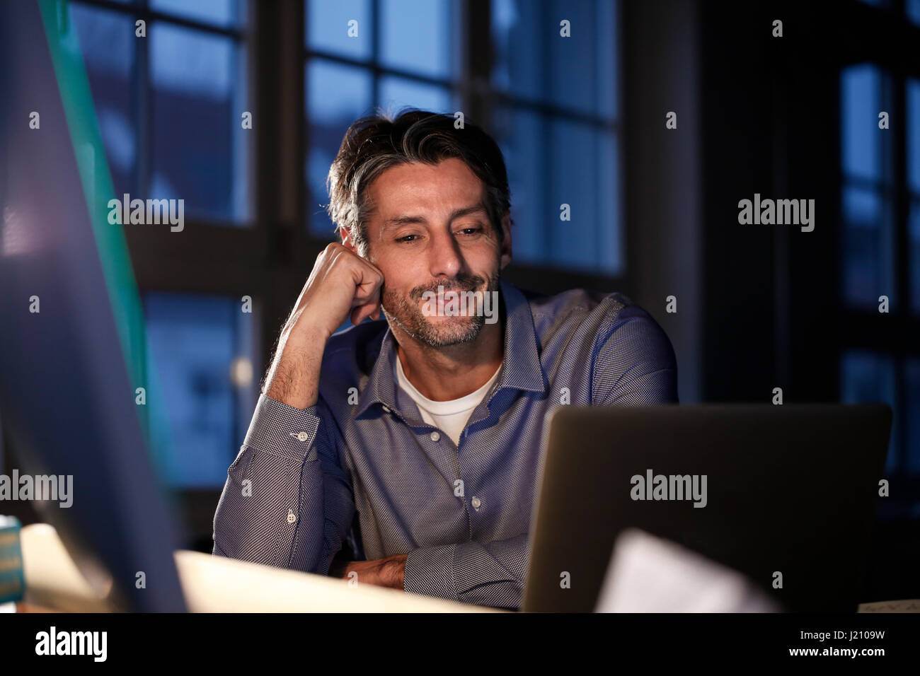 Man working late in office Stock Photo - Alamy