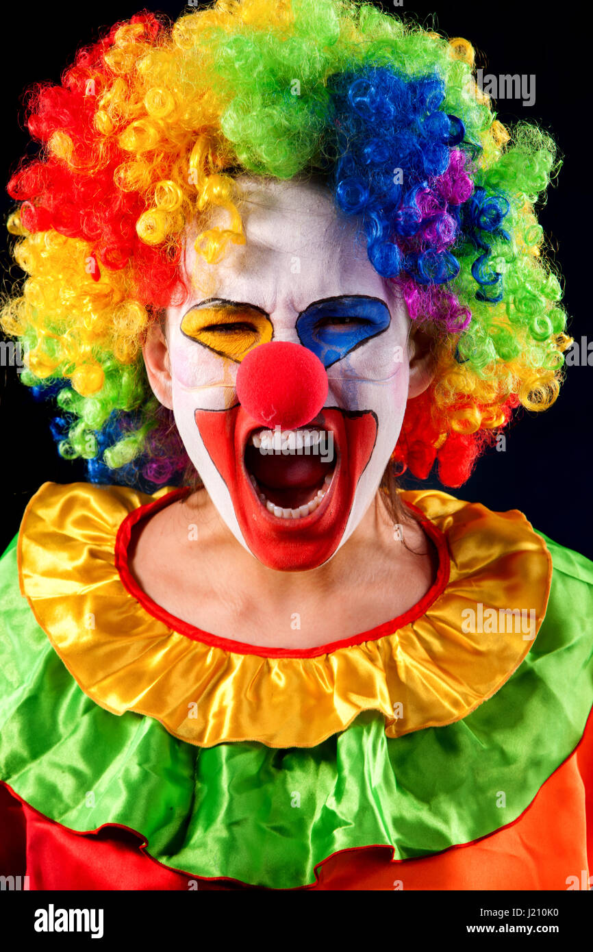 Mad clown on black background. Portrait of crazy woman Stock Photo - Alamy