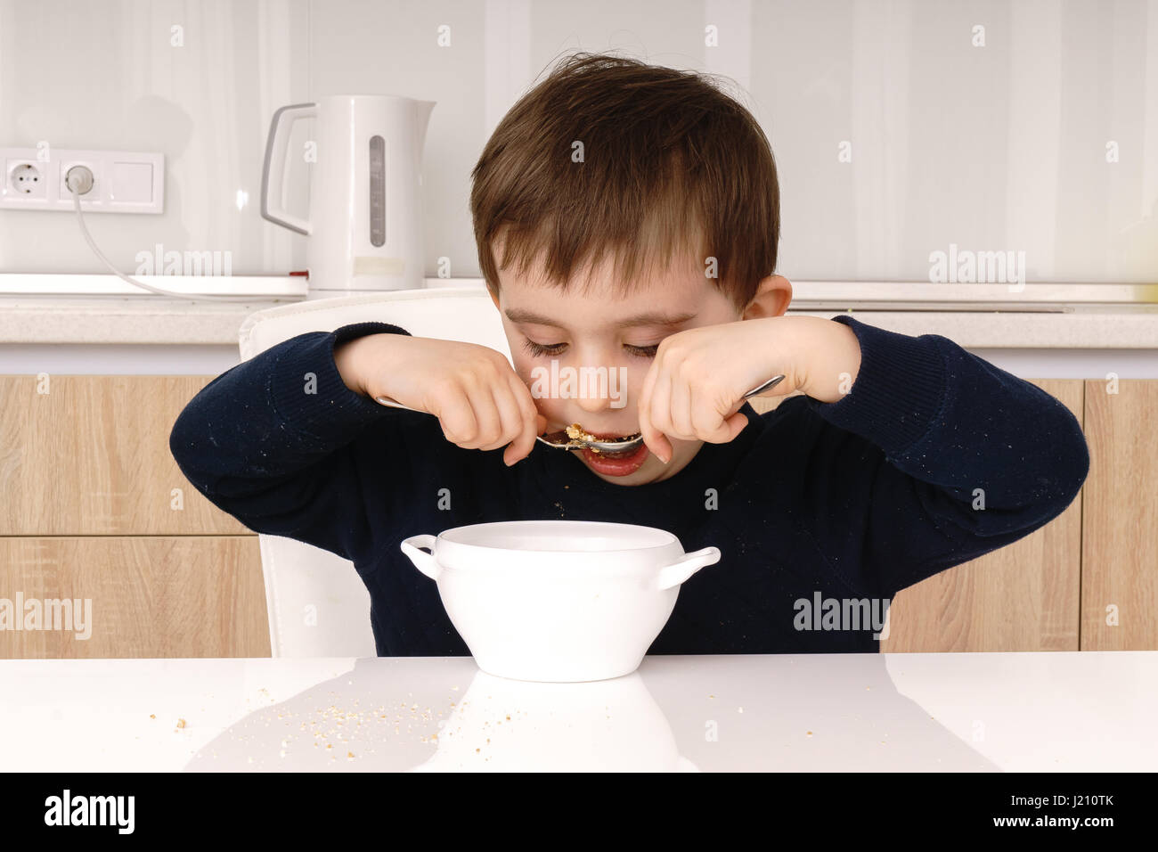 Happy little boy having healthy breakfast Stock Photo - Alamy