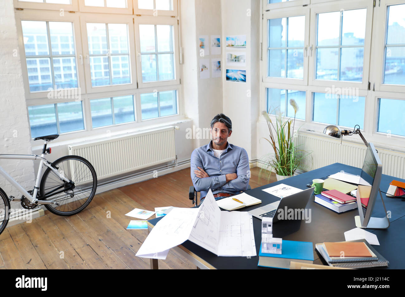 Man at desk in office thinking Stock Photo - Alamy