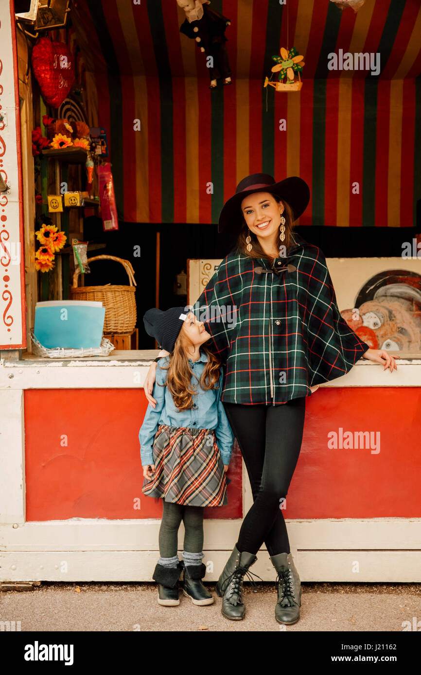 Young woman and little girl standing in front of stand at fair Stock ...