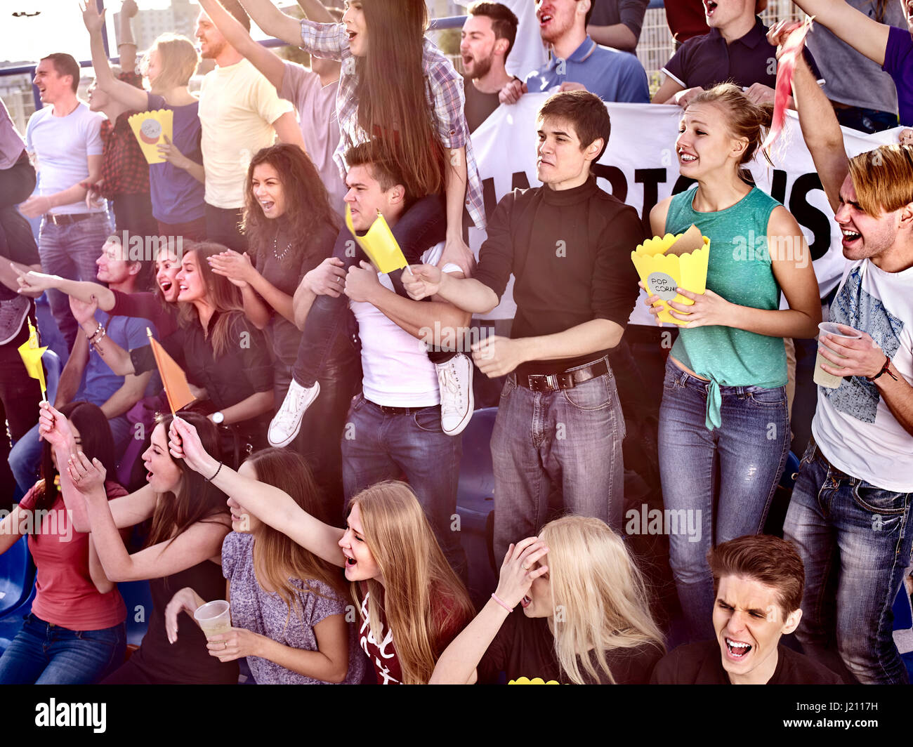 Fans cheering in stadium and eating popcorn Stock Photo - Alamy