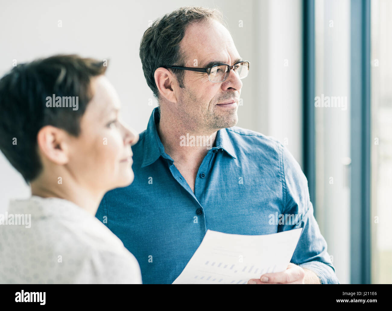 Colleagues looking out window hi-res stock photography and images - Alamy