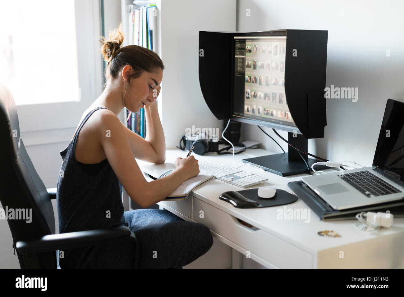 Female photographer editing images at desk Stock Photo - Alamy