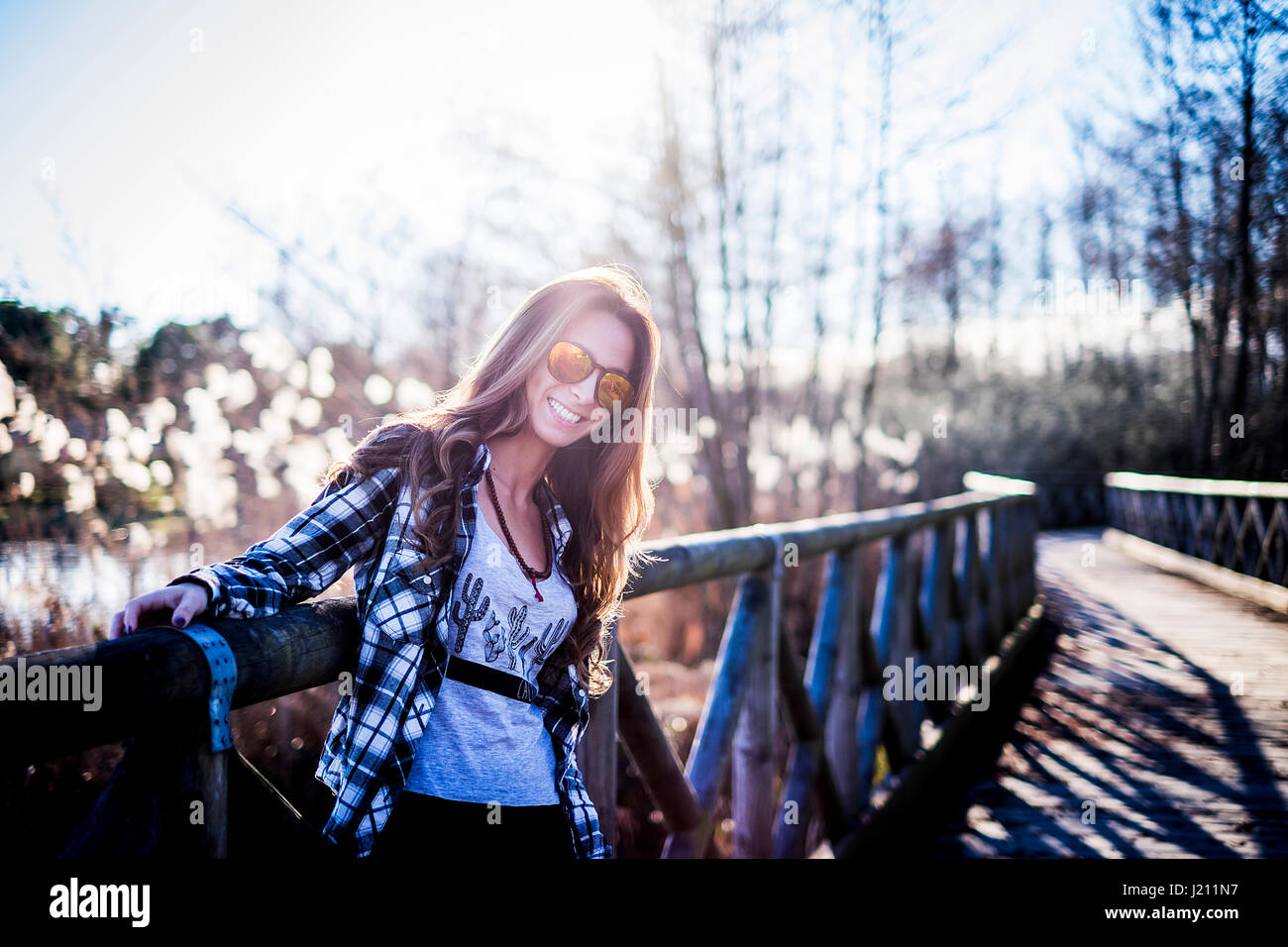 Woman standing on bridge, smiling Stock Photo - Alamy