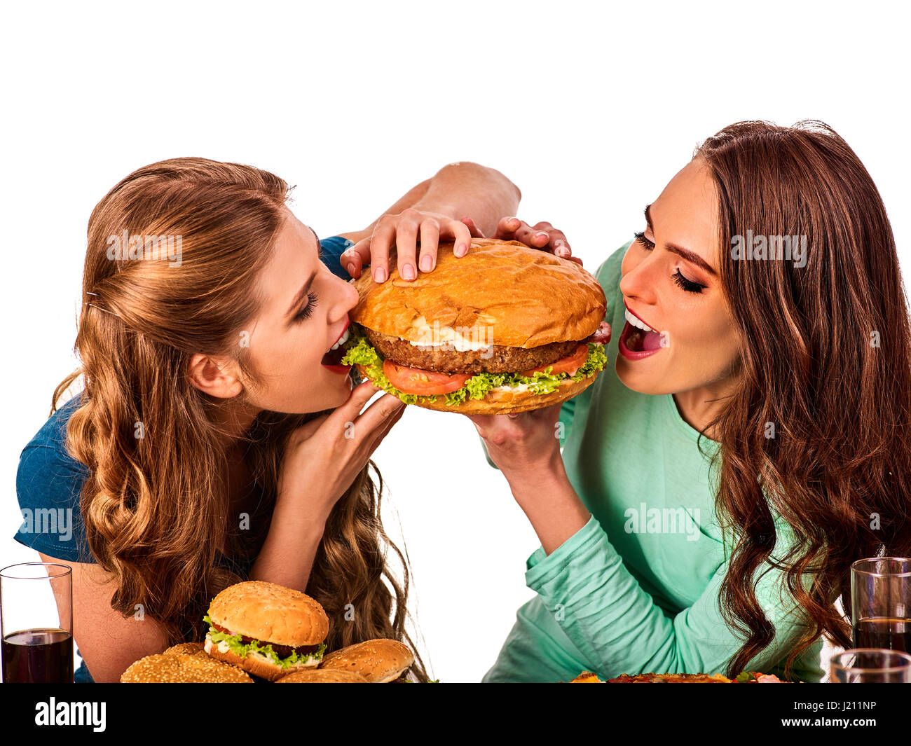 Women eating fast food. Gils eat hamburger with ham Stock Photo - Alamy