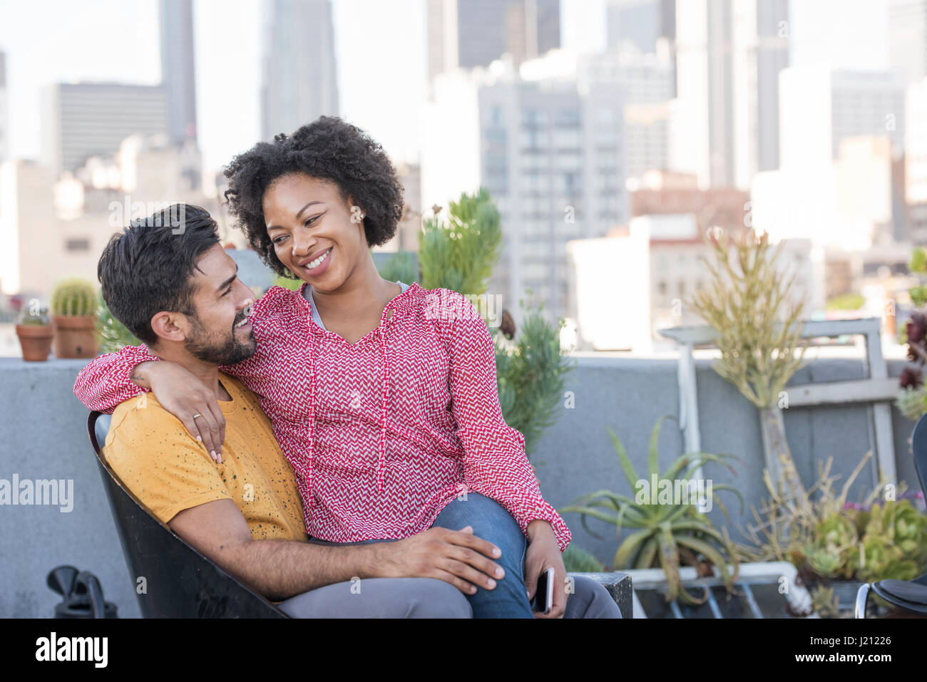 Couple sitting on rooftop terrace Stock Photo - Alamy