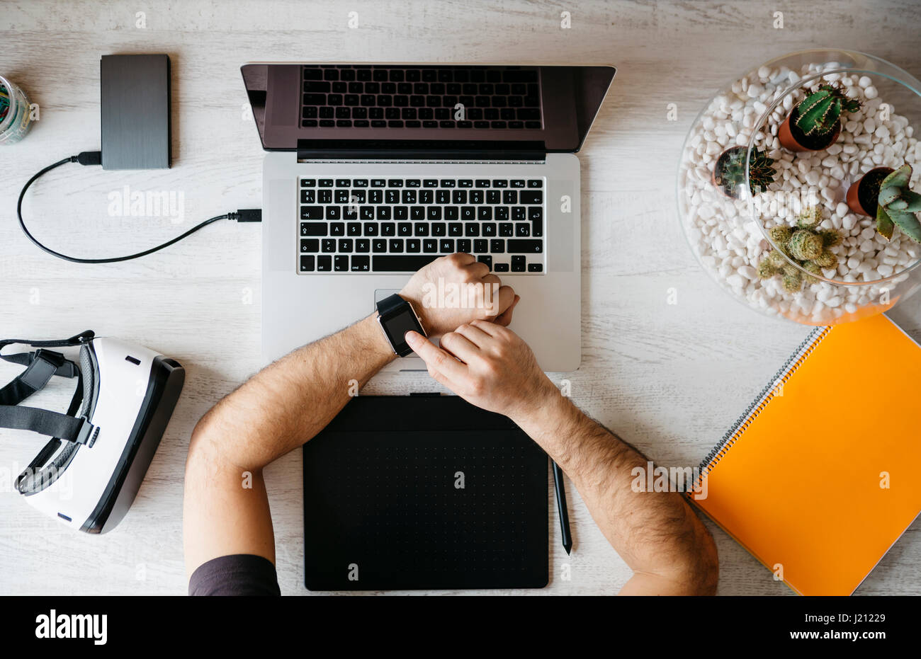 Man using smartwatch at desk, top view Stock Photo - Alamy