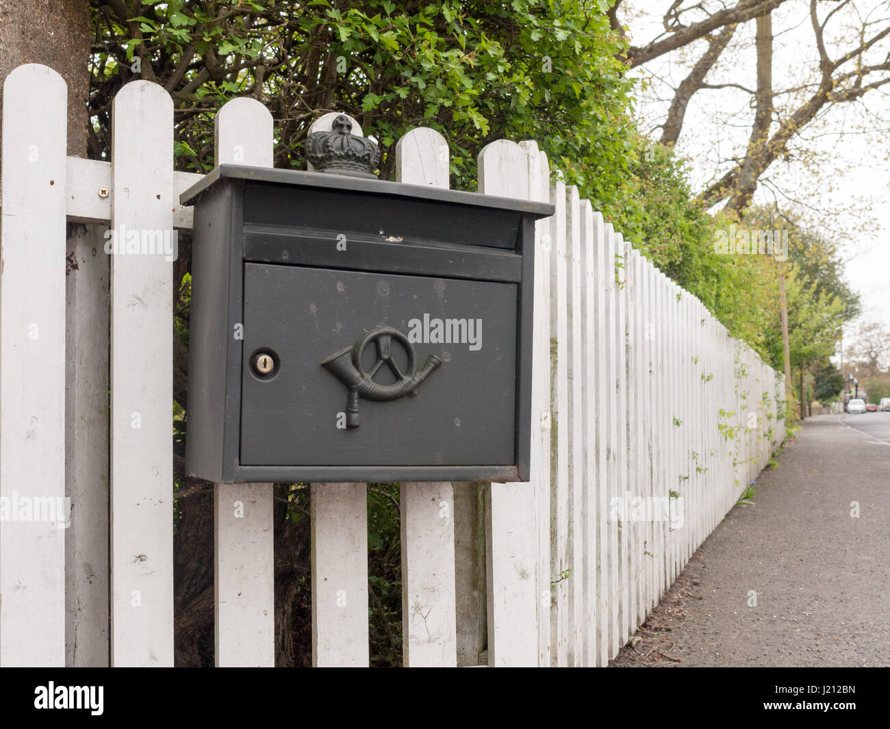 an interesting and unique black post box outside locked with an icon ...