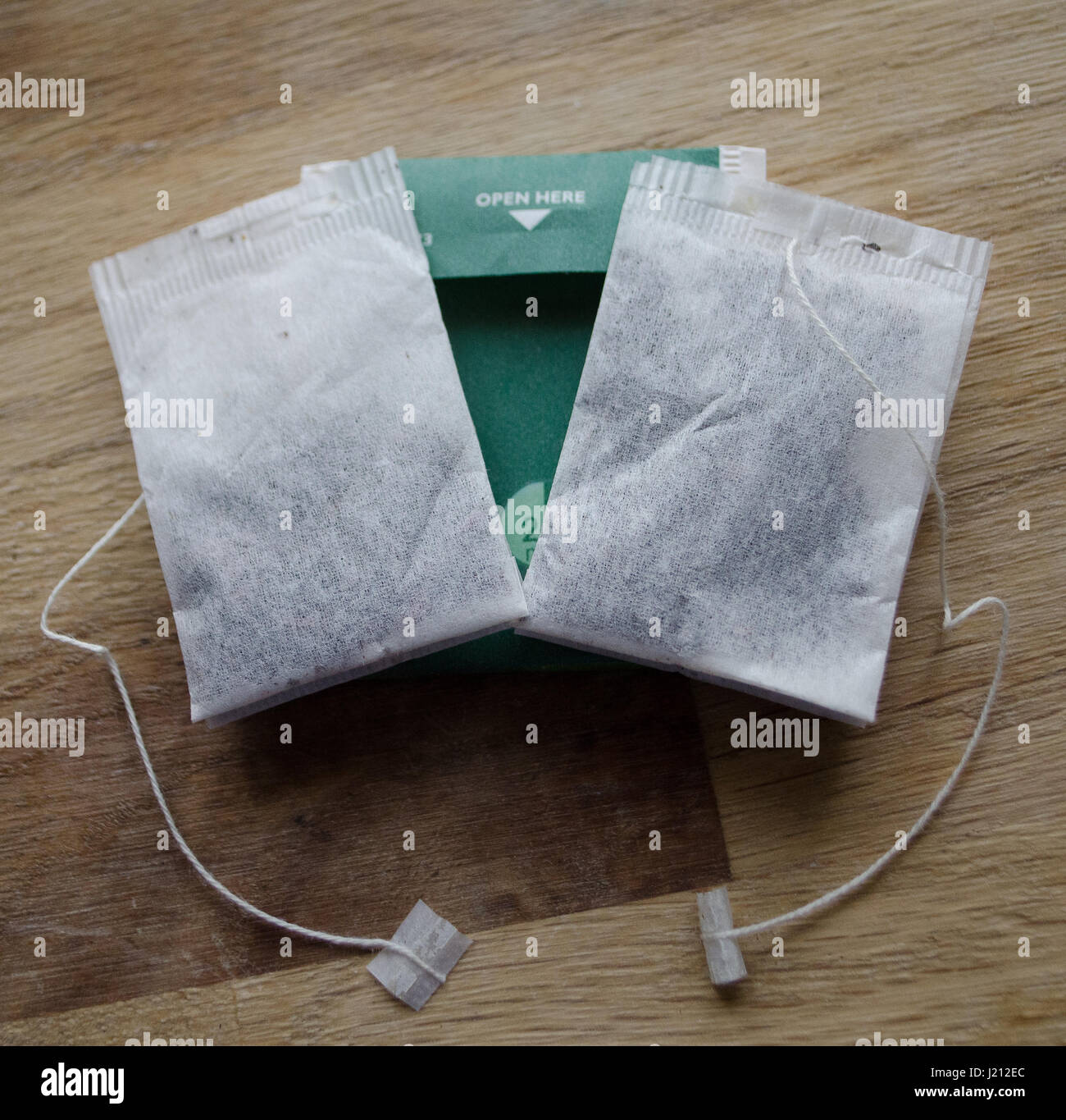 Two tea bags on wooden bench close up Stock Photo - Alamy