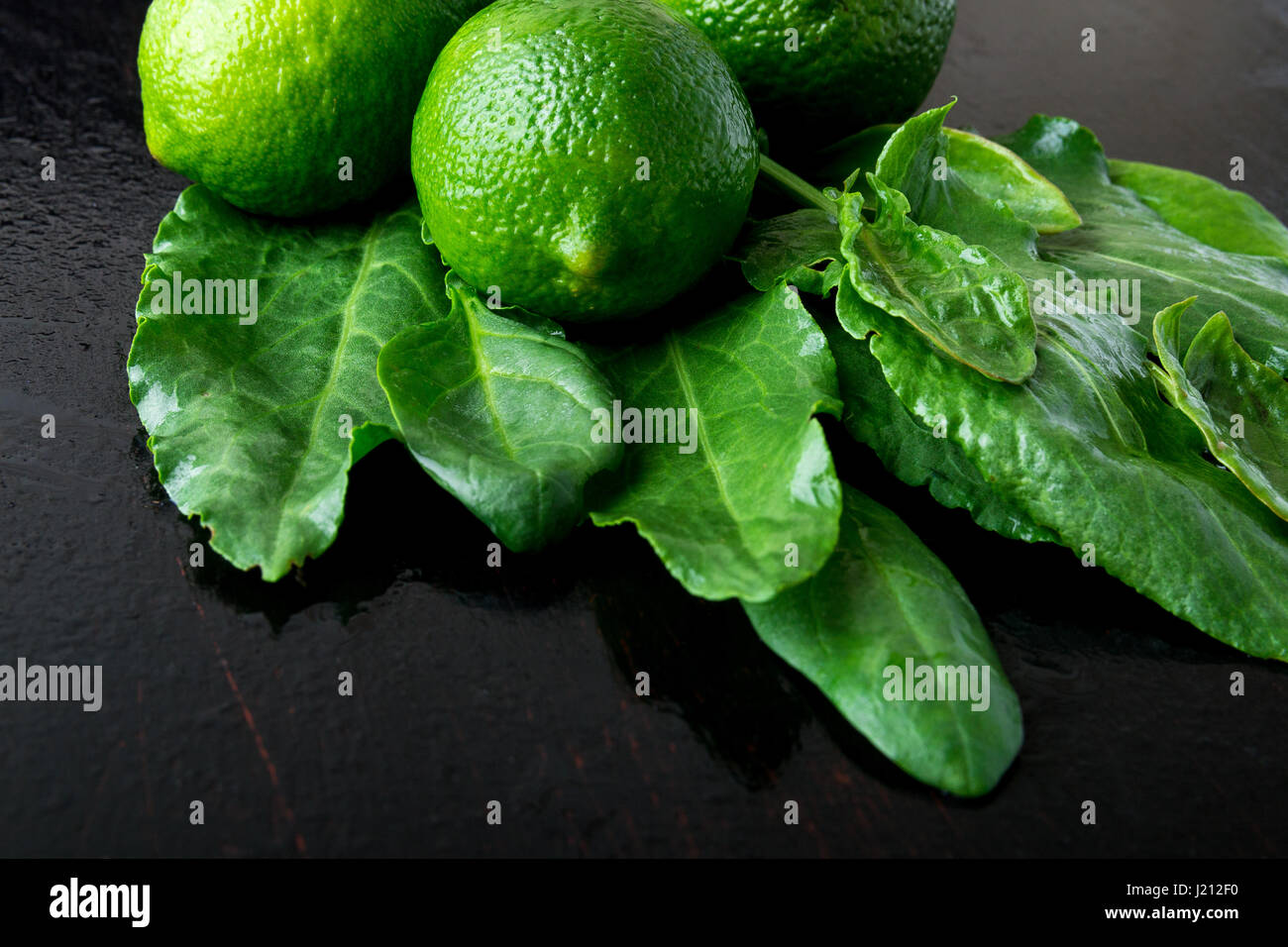 Wet spinach and lime on black background. Green fruit. Detox. Fresh ...