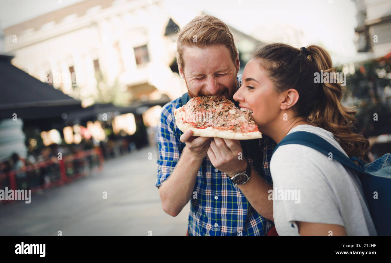 Positive happy students eating pizza on street Stock Photo - Alamy