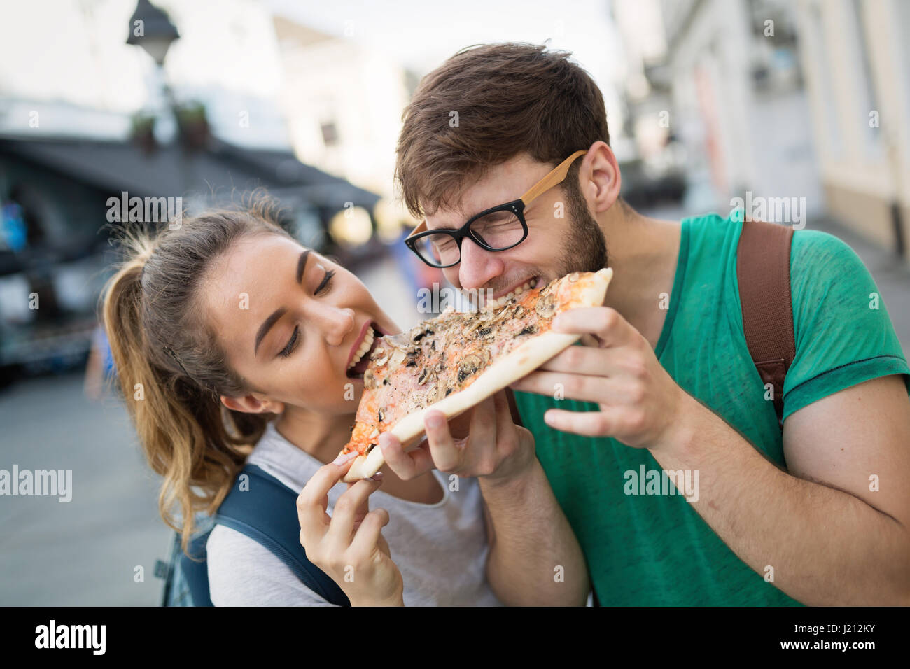Positive happy students eating pizza on street Stock Photo - Alamy