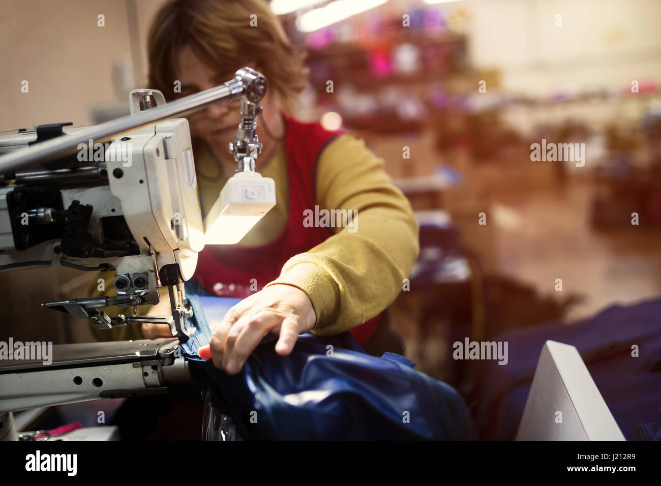 Woman working in sewing industry on machine Stock Photo - Alamy