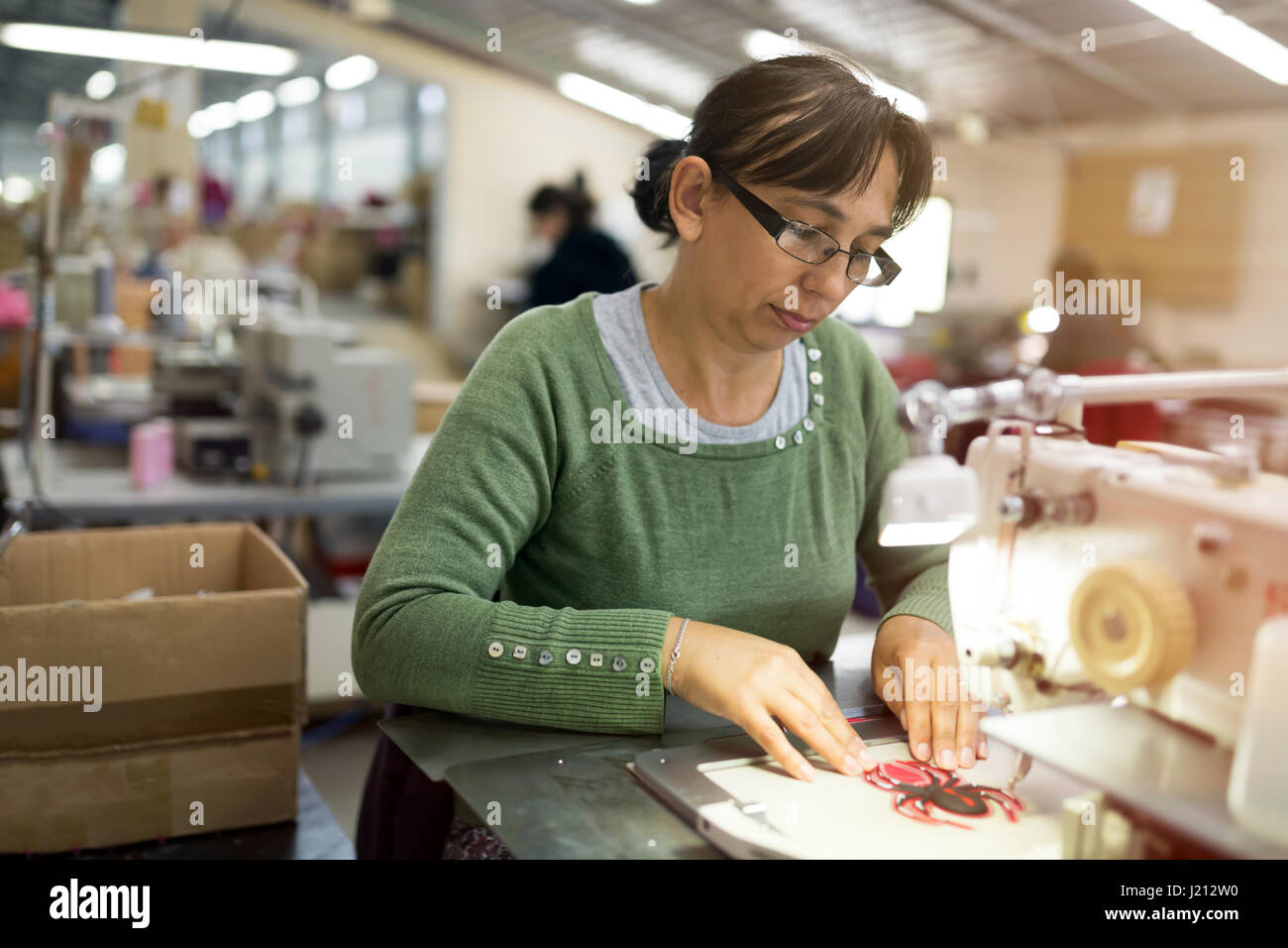Woman working in sewing industry on machine Stock Photo - Alamy