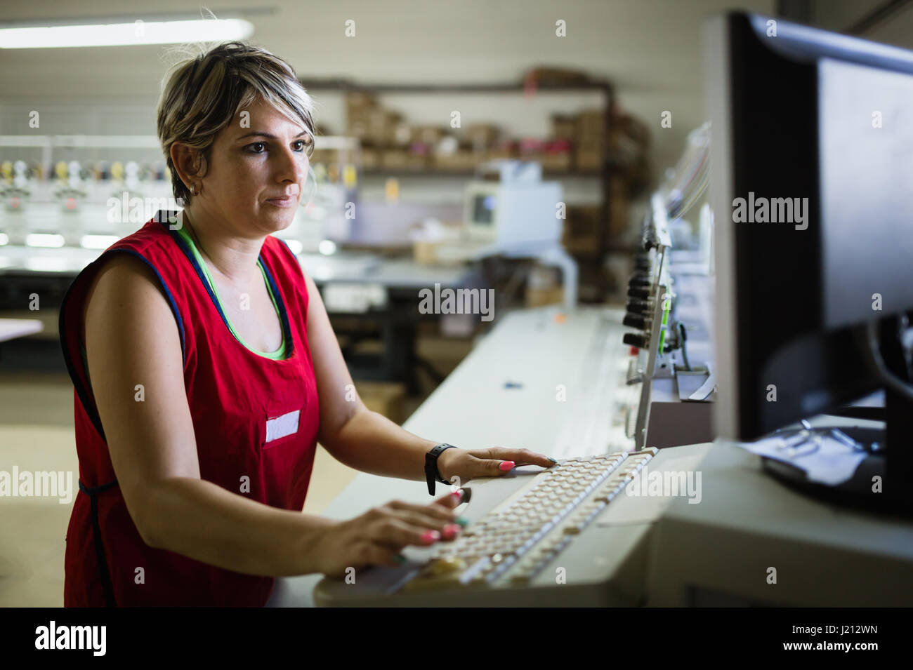 Female employee working on clothing fabric production Stock Photo - Alamy