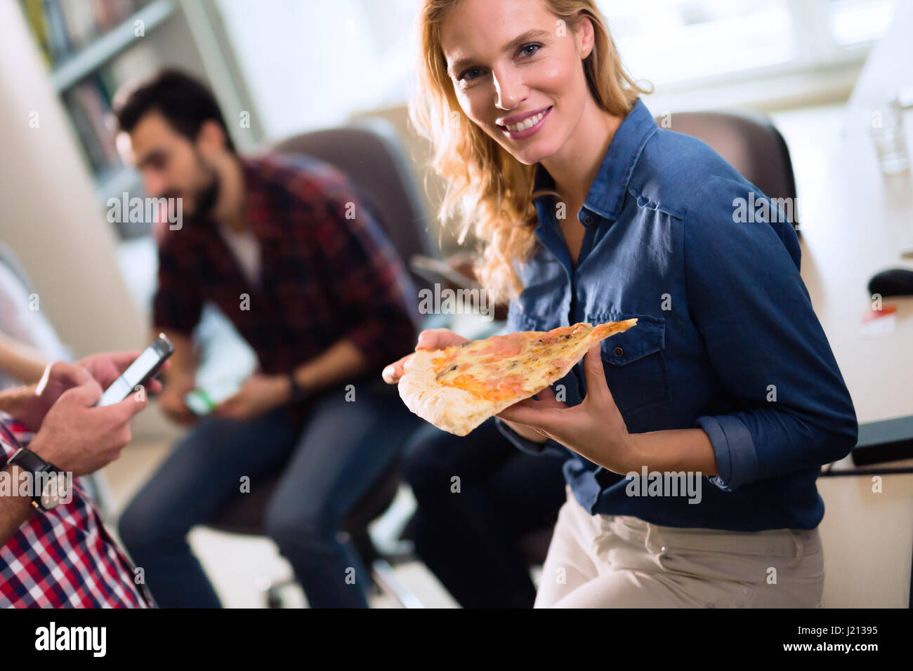 Coworkers eating pizza during work break at office Stock Photo - Alamy