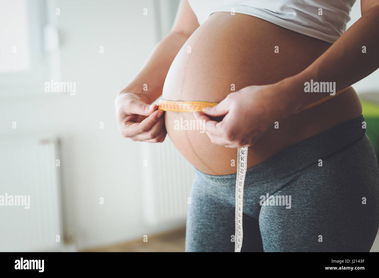 Beautiful belly growth during pregnancy beaing measured Stock Photo - Alamy