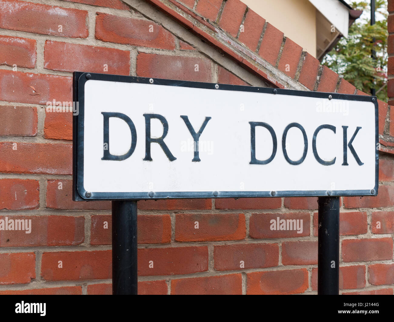 a black and white street sign saying dry dock with brick background ...