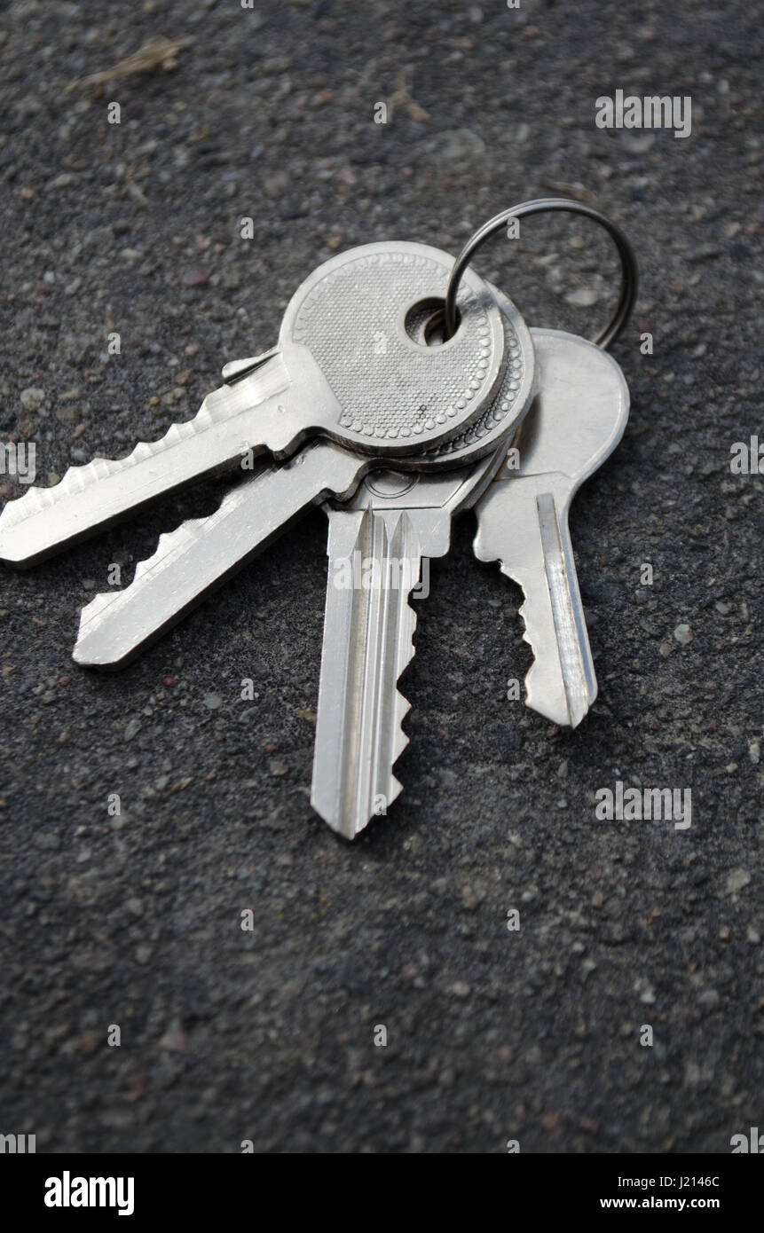 Keyring with four keys on concrete close up Stock Photo - Alamy
