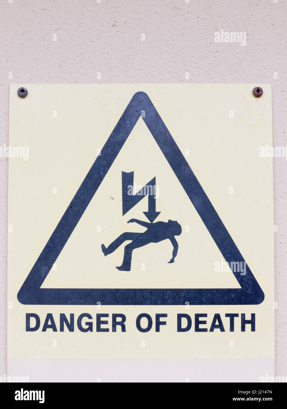 a white yellow and black close up sign on the wall saying danger of ...