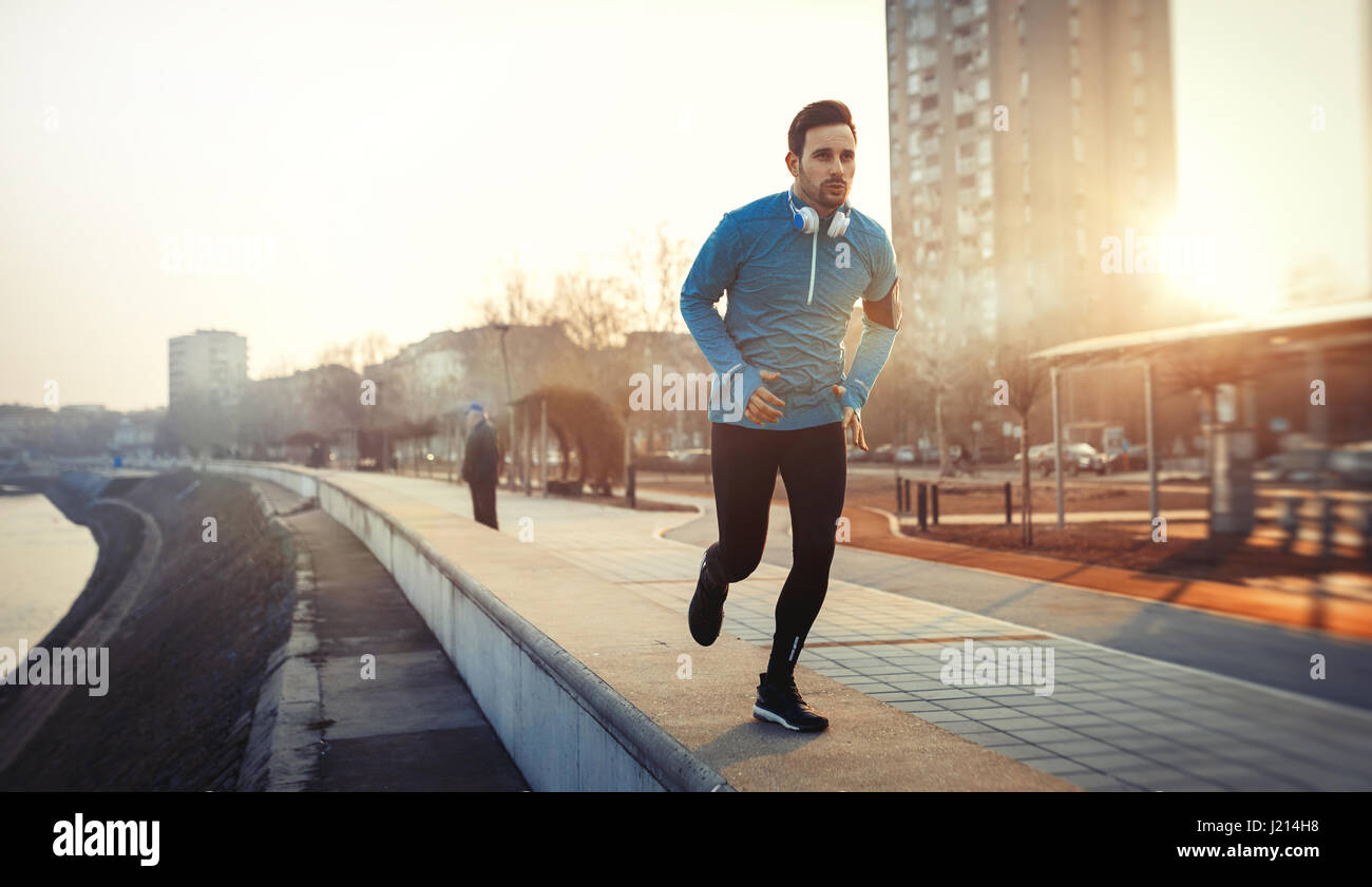 Handsome sportsman exercising outdoor by jogging and running Stock ...