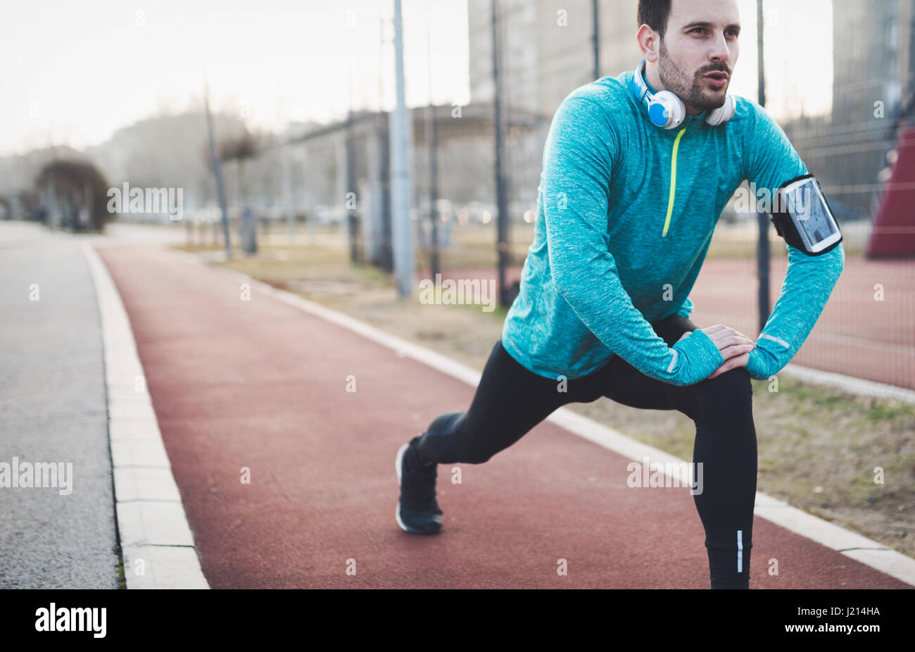 Handsome man stretching before exercising and running Stock Photo - Alamy