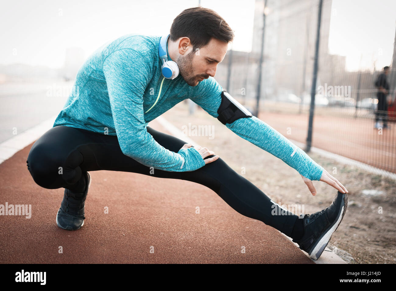 Handsome active runner male stretching before jogging Stock Photo - Alamy