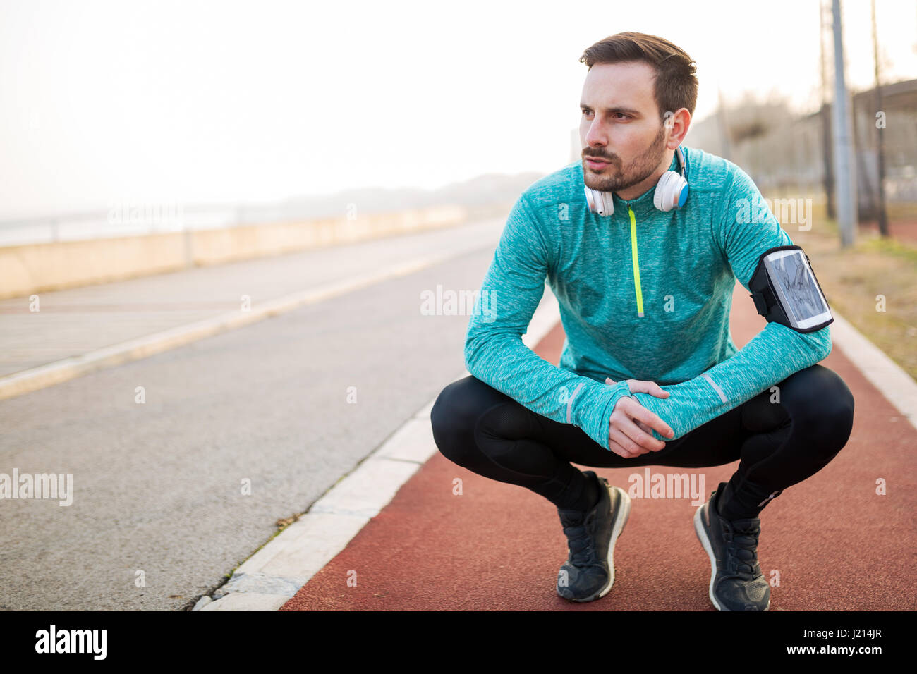Sporty handsome man resting after jogging exercise Stock Photo - Alamy