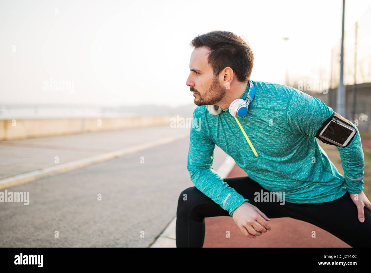 Handsome active runner male stretching before jogging Stock Photo - Alamy
