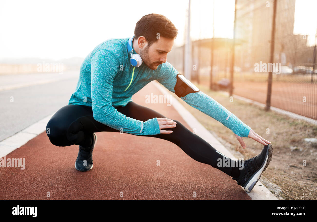 Handsome active runner male stretching before jogging Stock Photo - Alamy