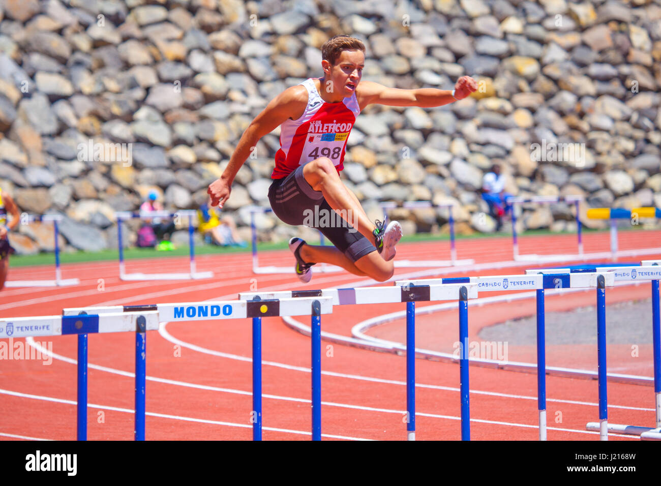 young men doing Hurdling on the track and field stadium CIAT in Santa ...