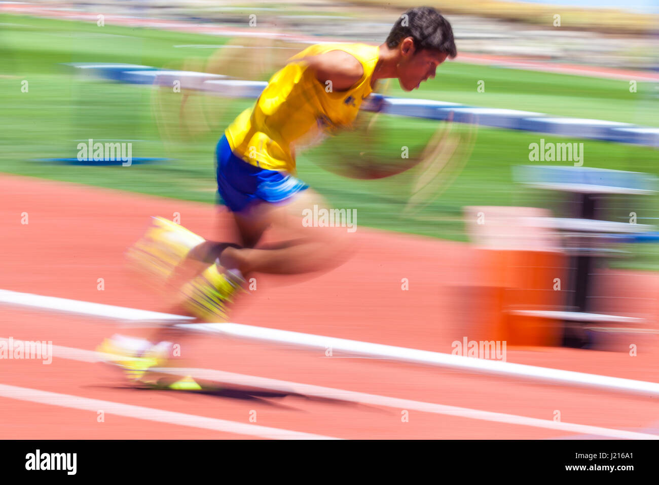 young men doing Hurdling on the track and field stadium CIAT in Santa ...