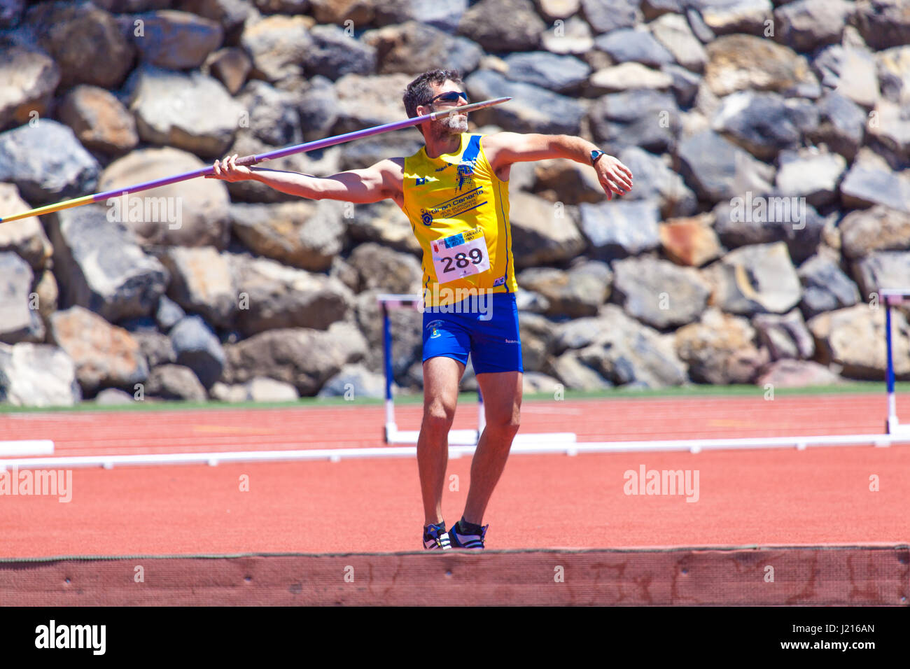 Young sportsman throwing javelin on a track and field competition Stock ...