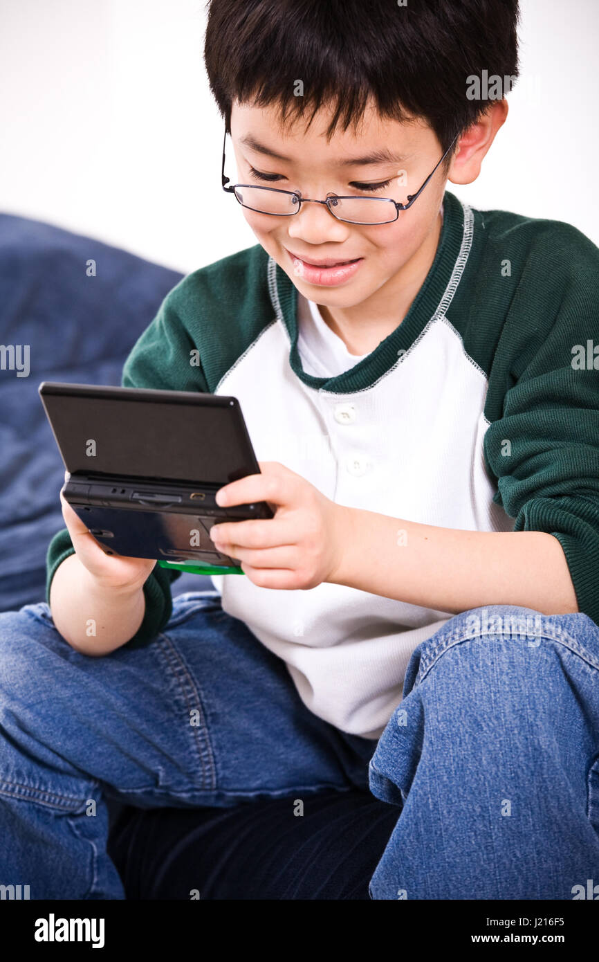 A shot of an asian boy playing electronic games Stock Photo - Alamy