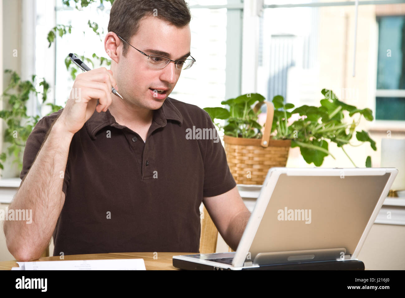 A caucasian man paying the bills by online banking at home Stock Photo ...