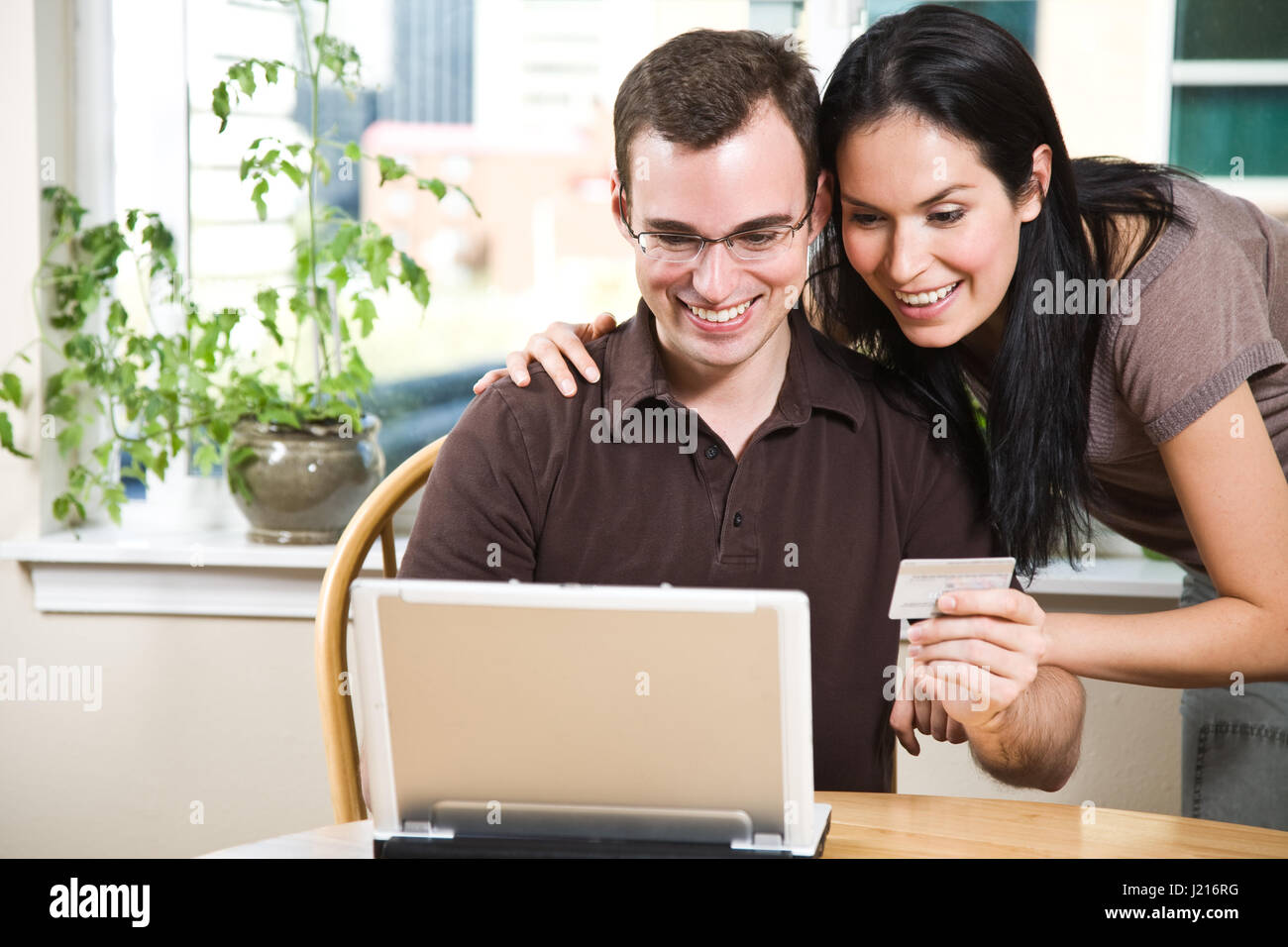 A happy couple holding a credit card shopping online Stock Photo - Alamy