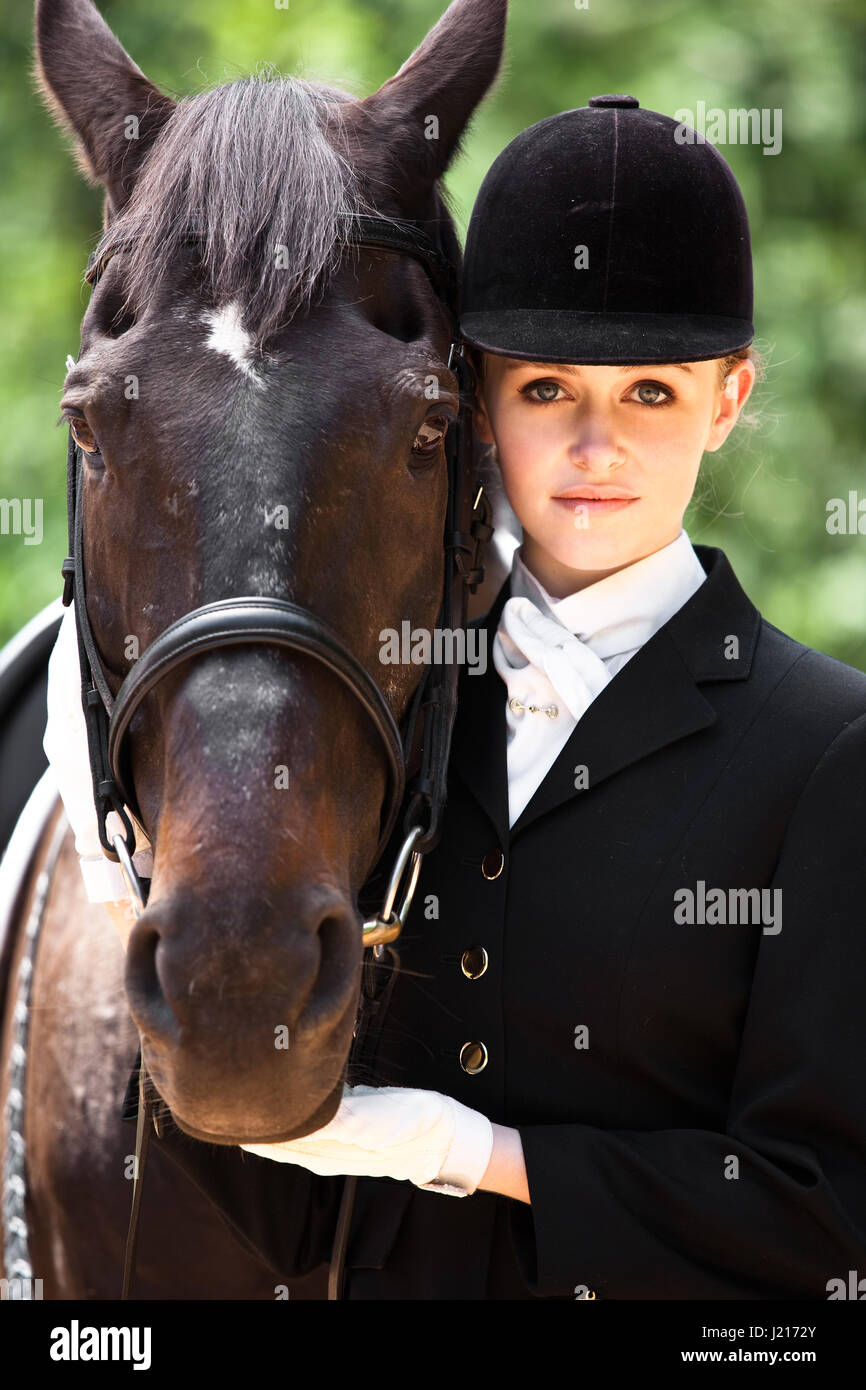 A caucasian girl getting ready for a horseback riding posing with her ...