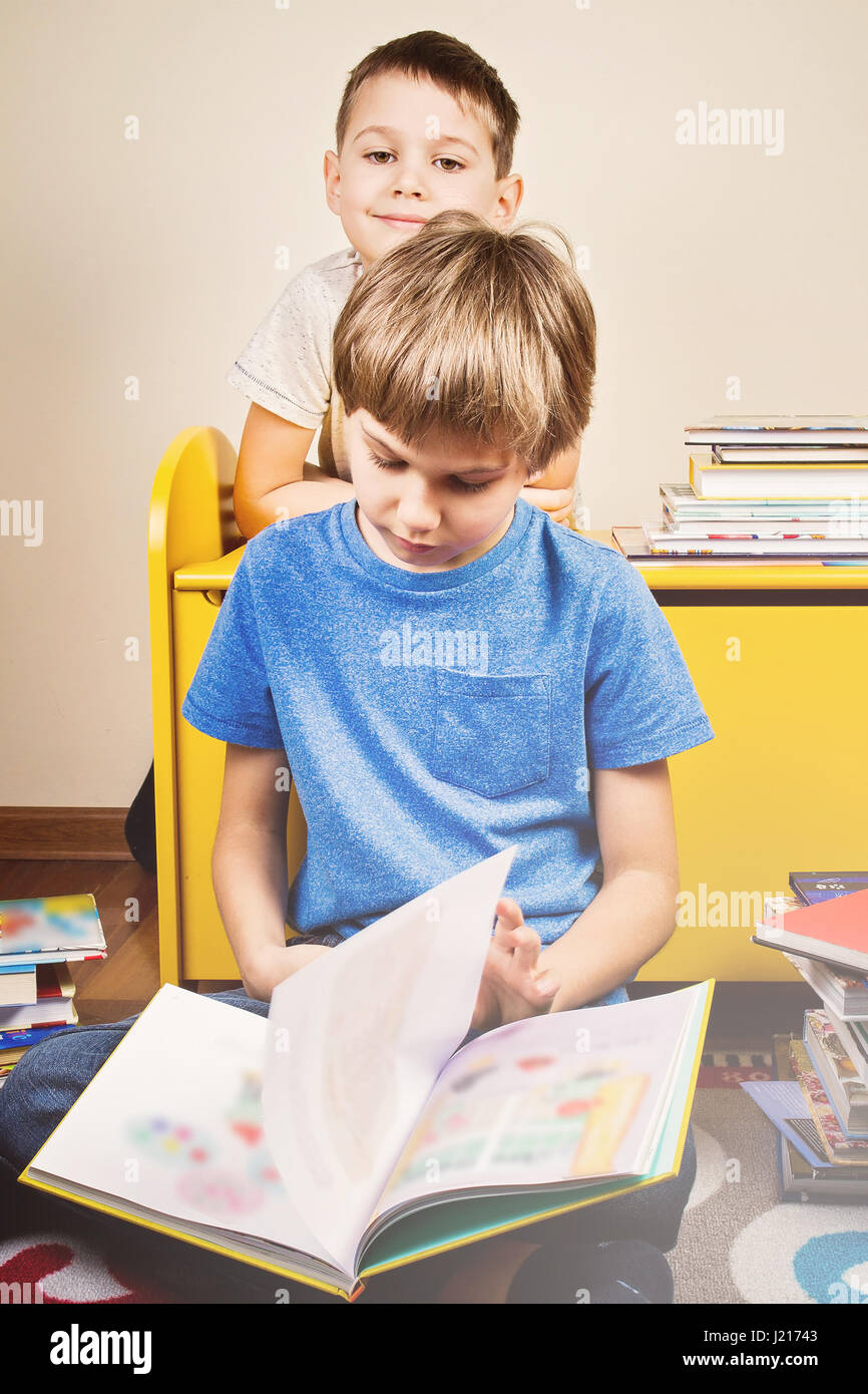 Kids reading a book. Boy reads a story to his brother at home Stock ...