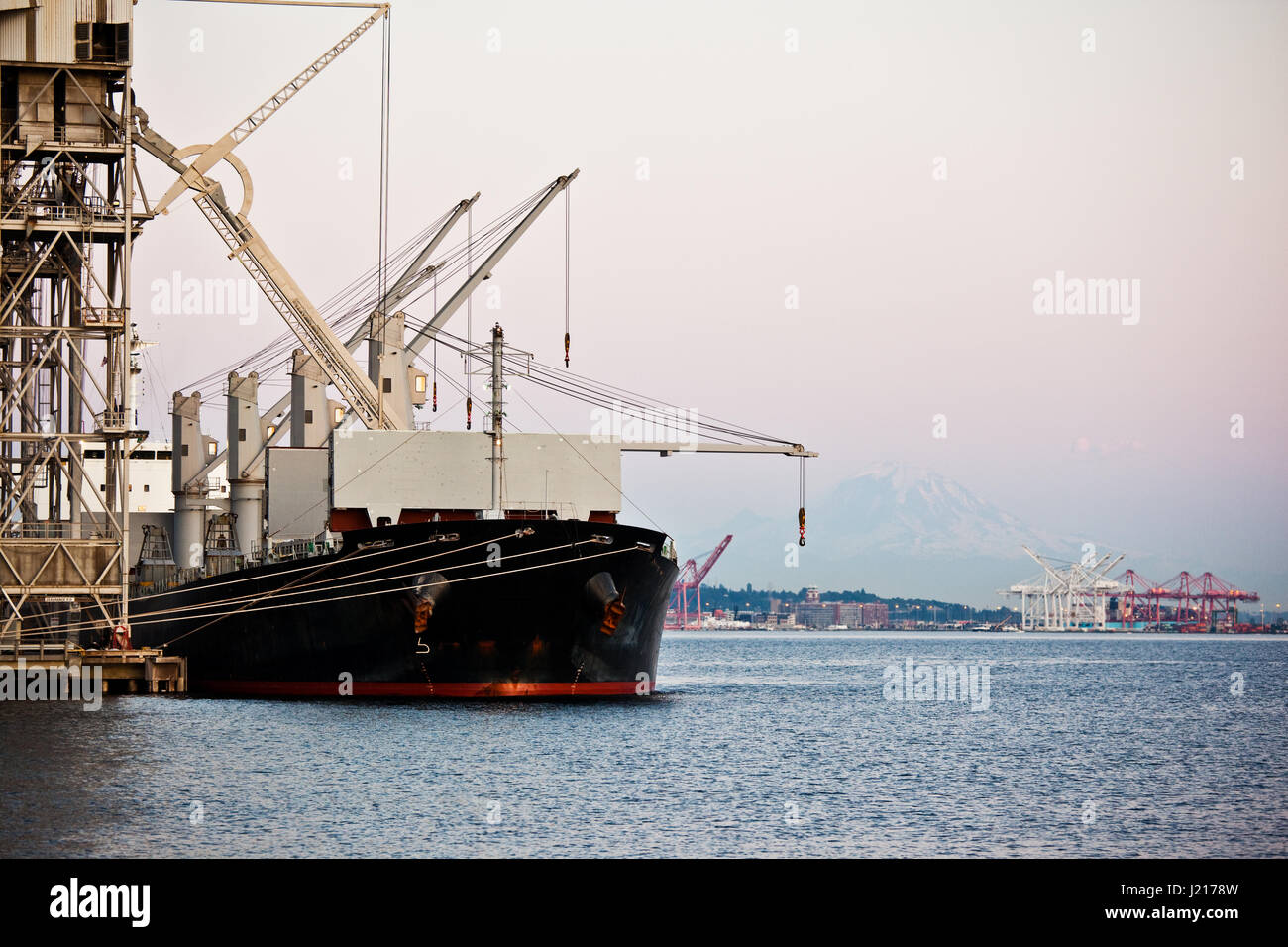 A shot of a shipping port with a ship loading or unloading shipment ...