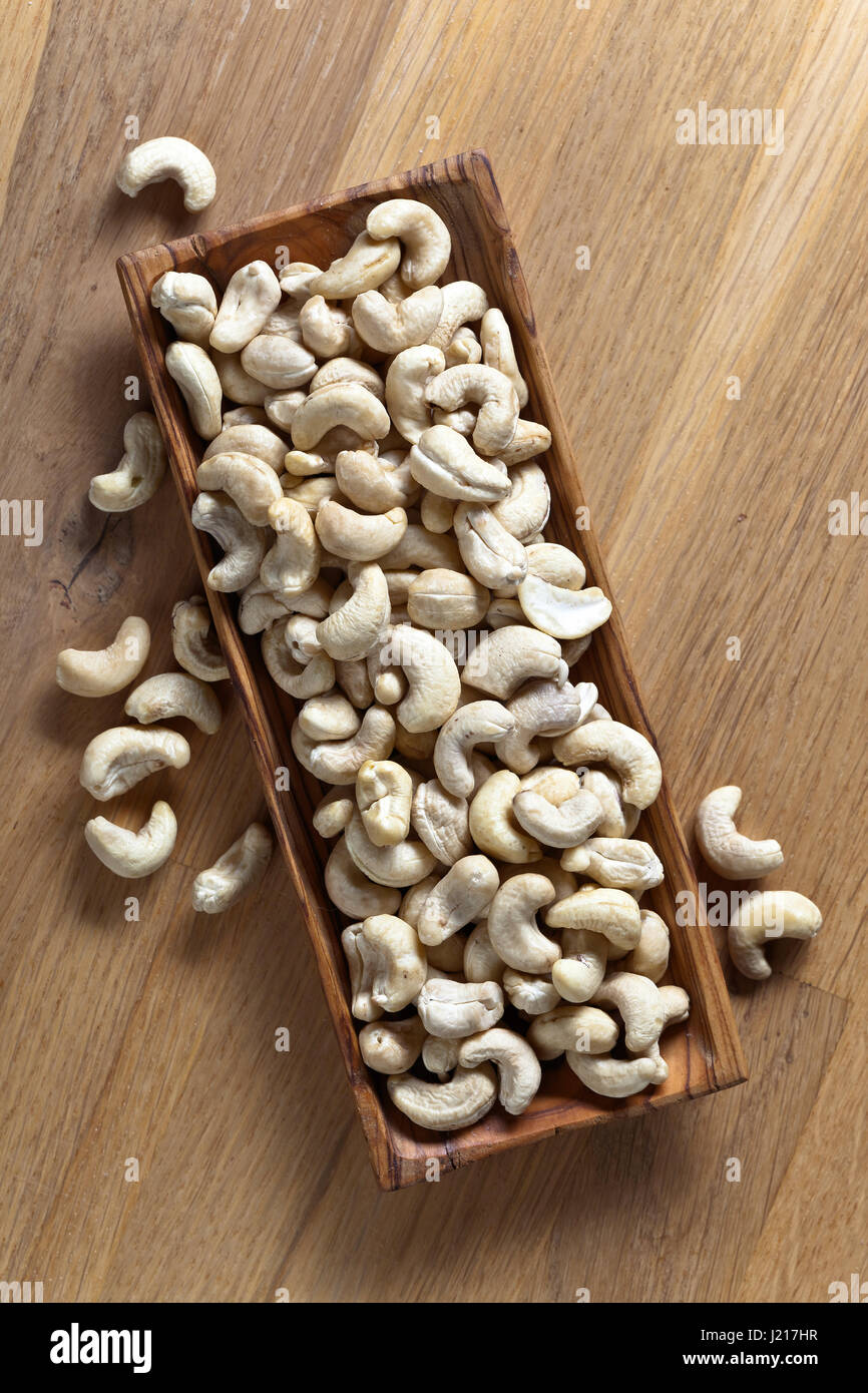 Cashews in old wooden dish on a kitchen table Stock Photo - Alamy