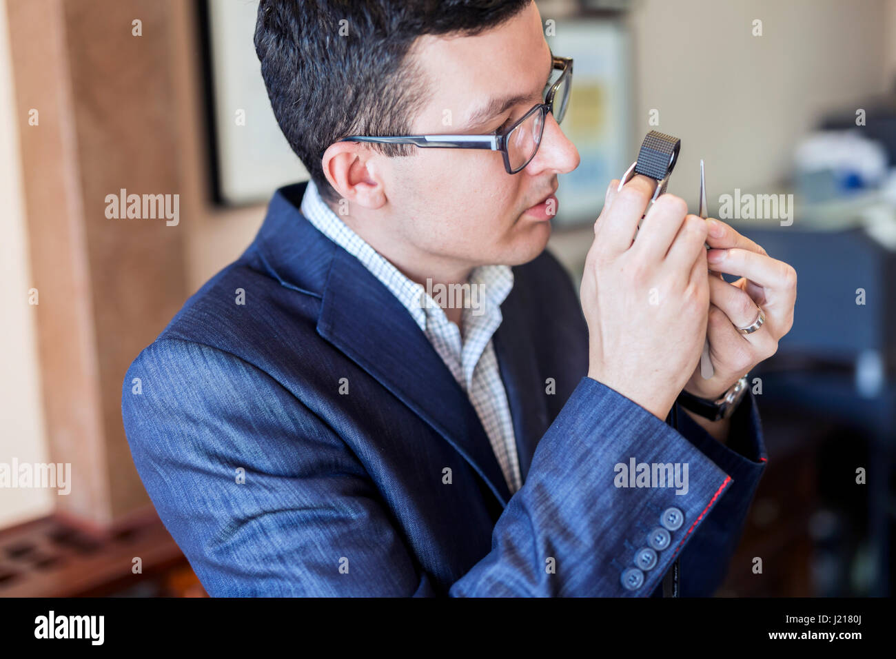 Jeweler looking at diamond through loupe to inspect it Stock Photo - Alamy