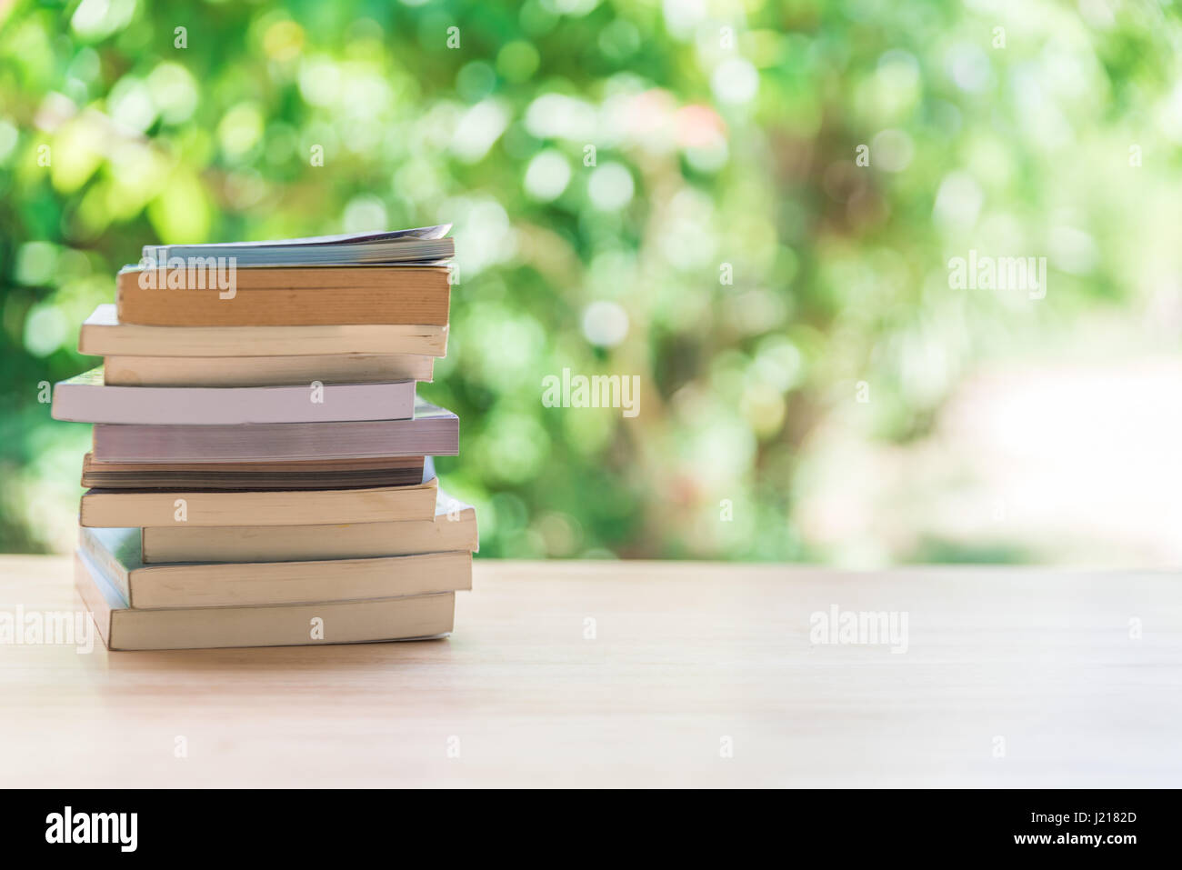 Book stack on wooden table Stock Photo - Alamy