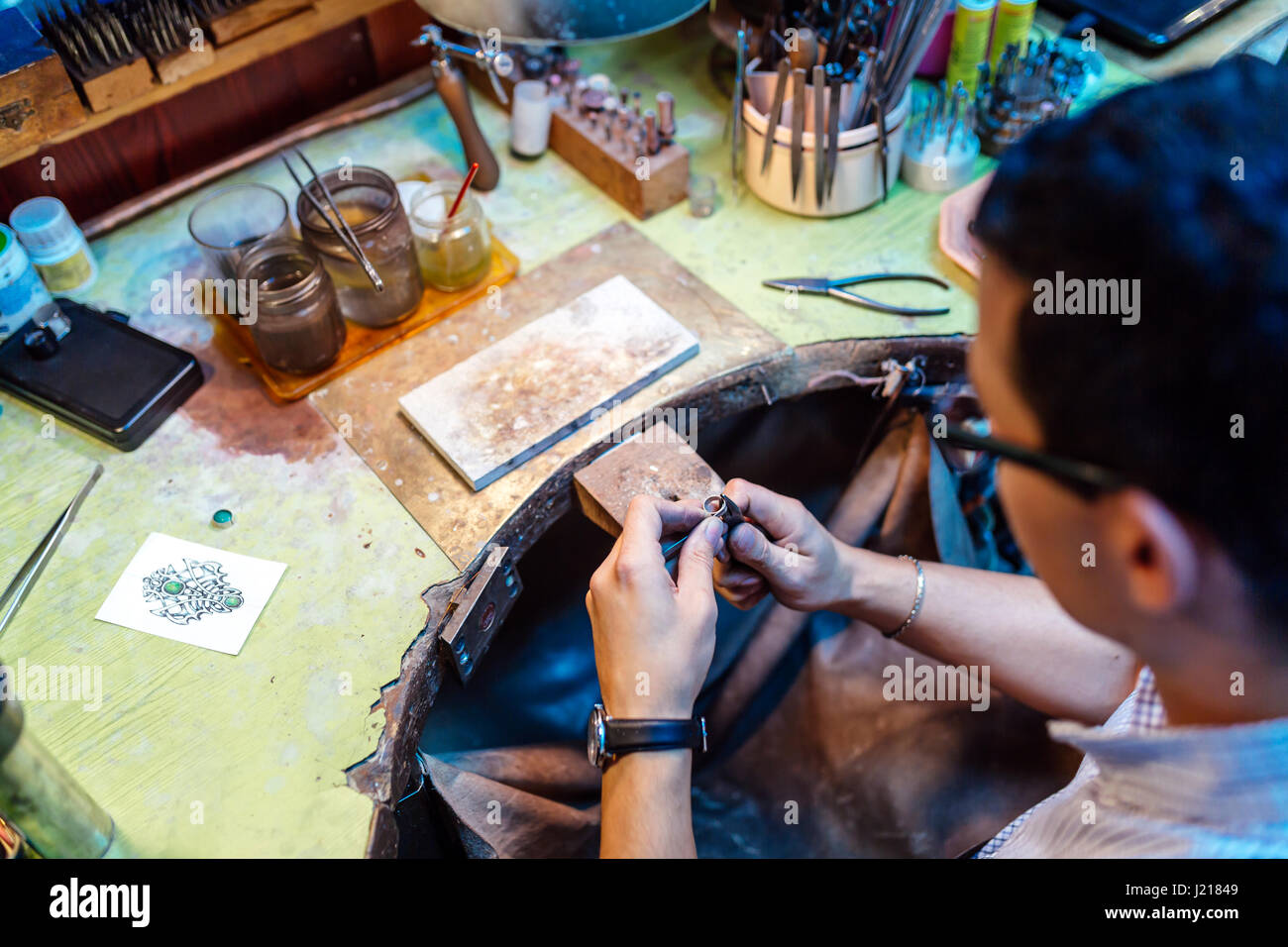 Goldsmith working on his bench, crafting jewelry Stock Photo - Alamy